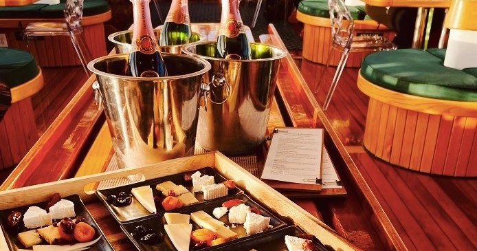 Three buckets of ice with Champagne in them and a plate with artisanal ...